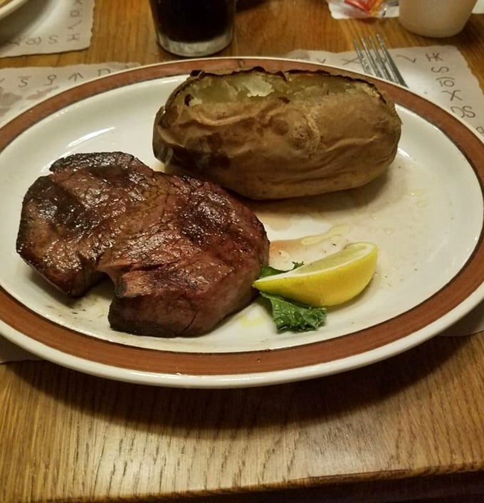 Simplicity at its finest: a perfectly cooked filet mignon alongside a baked potato, proving that sometimes less truly is more.