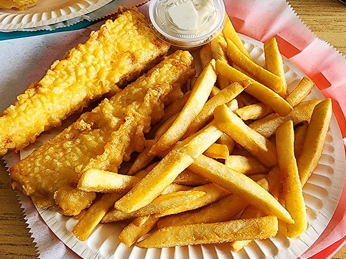 Golden-battered fish alongside perfectly crisp chips – this isn't just food, it's edible sunshine that makes you want to hum "Rule, Britannia" between bites.