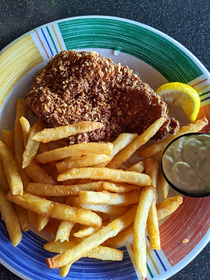 The star of the show: golden-battered fish atop a mountain of crispy fries. That tartar sauce isn't optional—it's essential supporting cast.