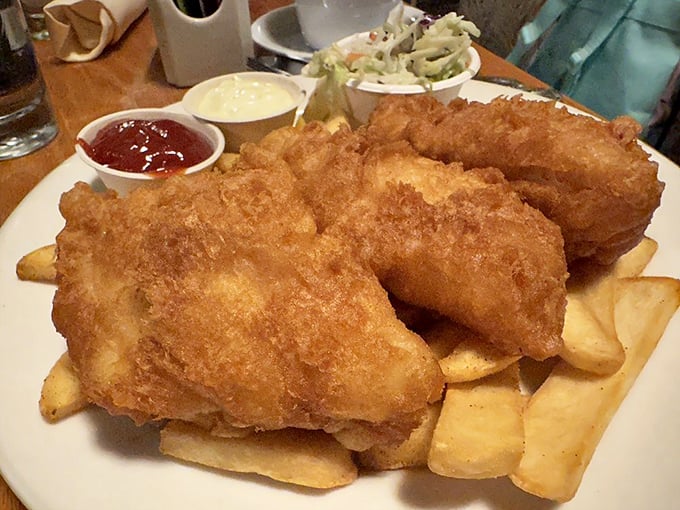 Golden-battered fish perched atop a mountain of crispy fries—this isn't just fish and chips, it's edible sunshine with a side of coastal bliss.