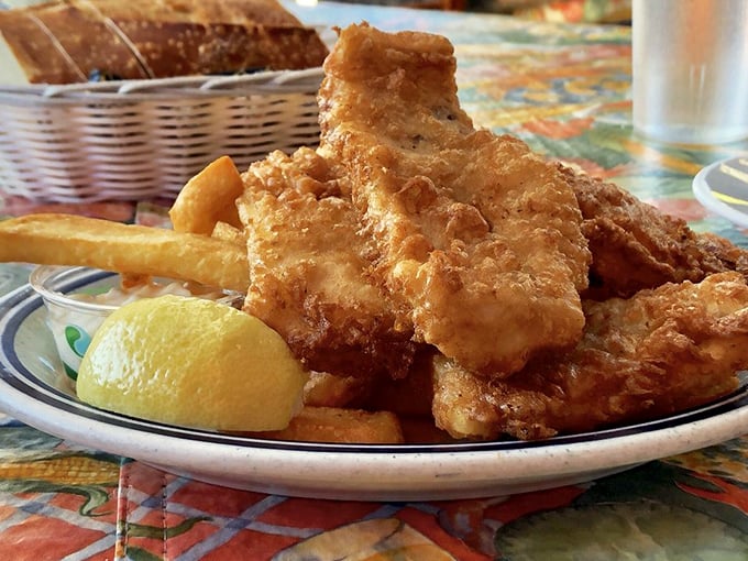 Golden armor of crispy batter protecting tender white fish within—this isn't just fish and chips, it's seafood royalty holding court.