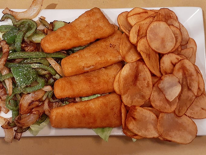 Golden-battered fish fillets with homemade chips and sautéed vegetables—proof that perfection doesn't need reinvention, just respect for tradition and technique.