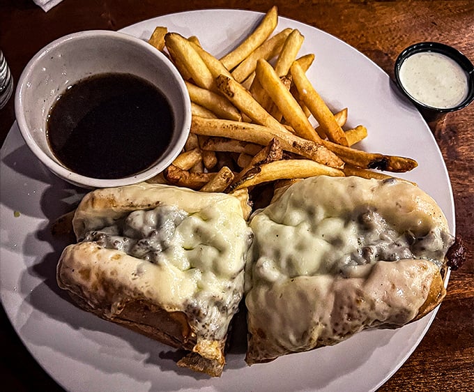 The legendary French Dip in its natural habitat – swimming alongside golden fries with that magical cup of au jus waiting for its dipping destiny.