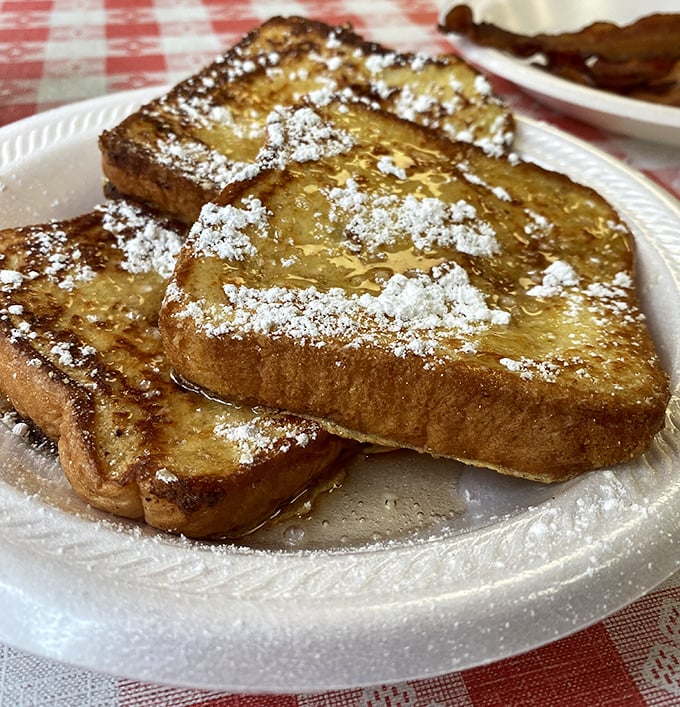 Golden, perfectly caramelized French toast dusted with powdered sugar. This isn't just breakfast—it's the reason alarm clocks were invented.
