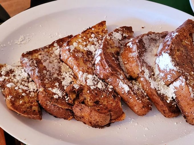 Golden-brown perfection! Shakabrah's legendary French toast arrives dusted with powdered sugar, crispy outside and custardy within—breakfast nirvana on a plate.