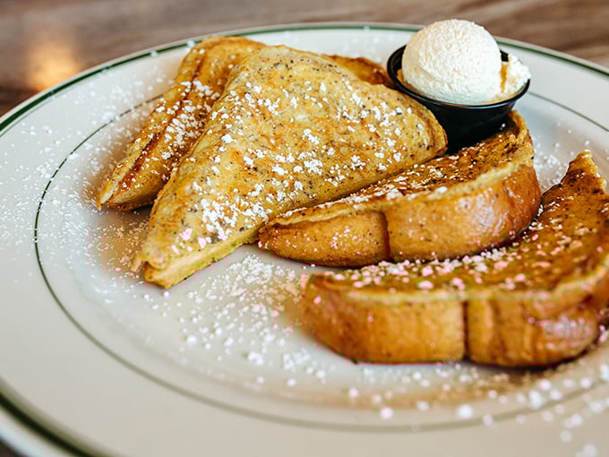 Golden-brown French toast dusted with powdered sugar snow – breakfast architecture so perfect it deserves its own HGTV special.