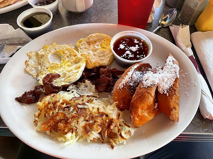Breakfast perfection doesn't happen by accident. This plate combines crispy hash browns, perfectly fried eggs, and French toast dusted with powdered sugar—the breakfast equivalent of a standing ovation.