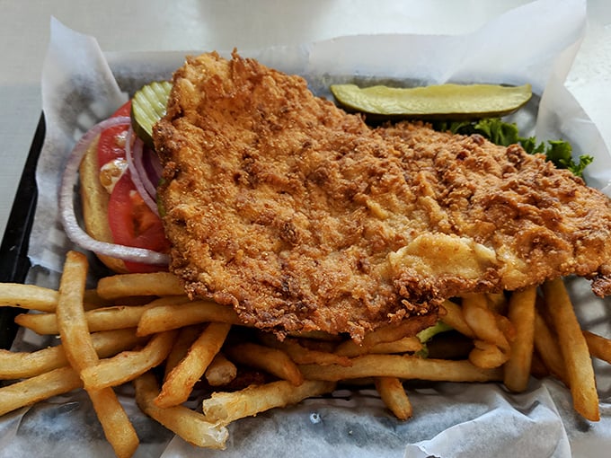 This isn't just fried catfish – it's a golden-armored delicacy that breaks apart with the gentlest pressure of a fork, surrounded by fries standing at attention.