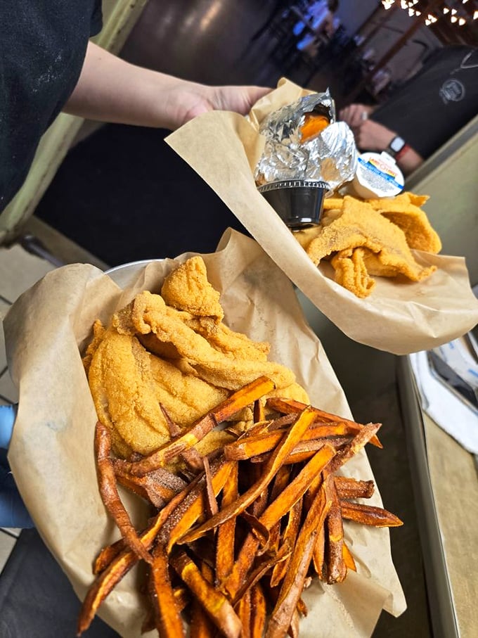 Golden-crusted catfish strips nestled beside sweet potato fries—a combination that makes taste buds stand up and salute the Mississippi flag.