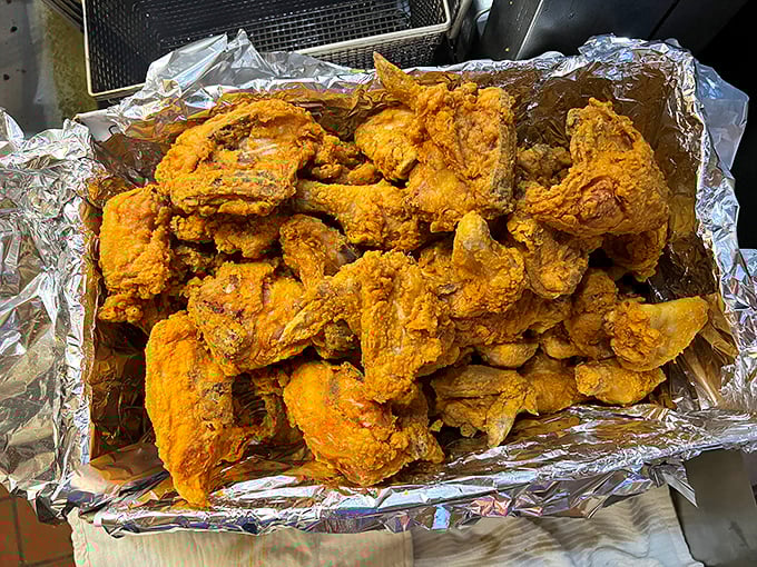 Golden-brown perfection piled high on foil. This isn't just fried chicken – it's edible Oklahoma history that makes your fingers glisten with delicious evidence.
