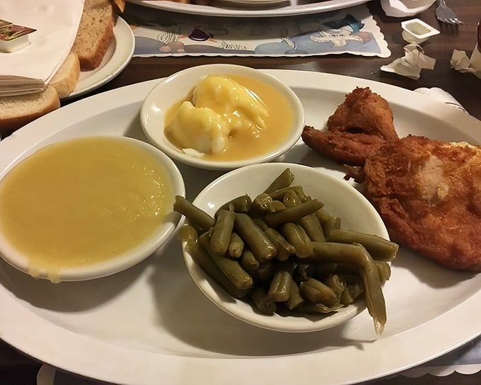 Golden-brown chicken alongside green beans, mashed potatoes, and that signature hot sauce – a plate that whispers "comfort" but shouts "flavor" with every bite.