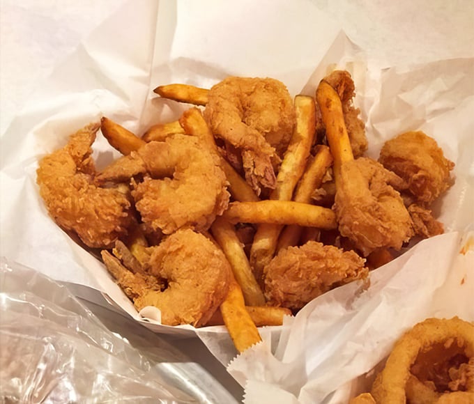 Golden-fried shrimp nestled among crispy fries – proof that sometimes the simplest preparations deliver the most satisfying bites.
