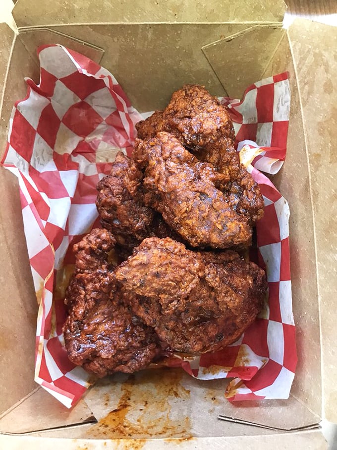 Golden-brown perfection nestled in a humble cardboard box. This isn't just fried chicken—it's edible artwork with a PhD in crunchology.
