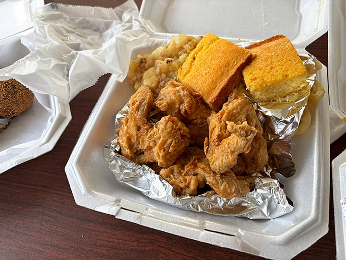 That golden-brown fried chicken arrives like a gift from the soul food gods, crispy perfection in a foam container.