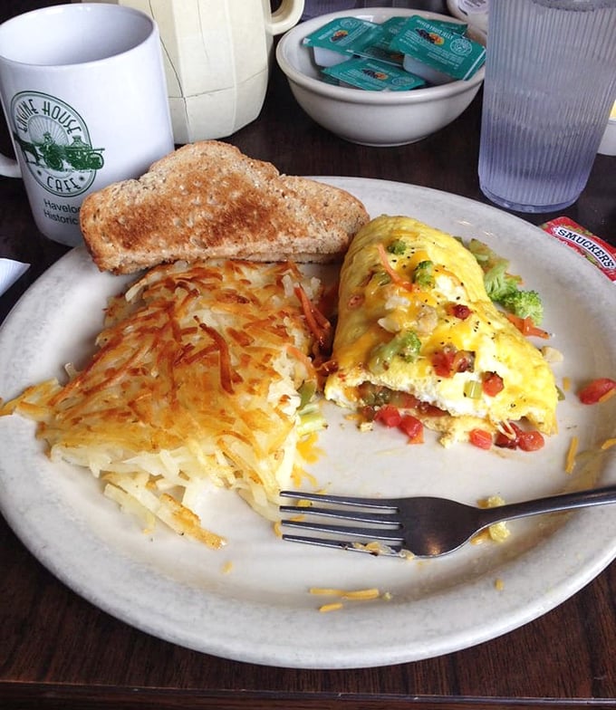 Golden, crispy hashbrowns meet a fluffy omelet loaded with vegetables – breakfast plate geometry at its finest right here.