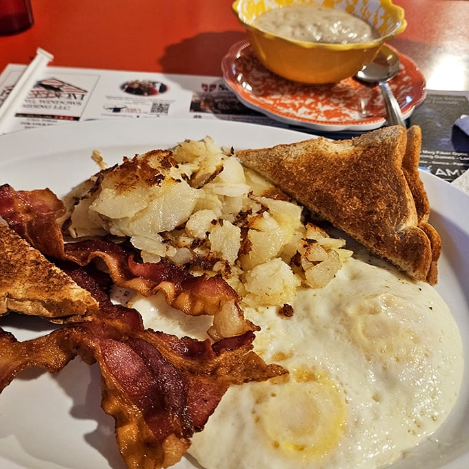 Breakfast perfection doesn't require fancy techniques—just perfectly crispy home fries, eggs with golden yolks, and bacon that would make vegetarians question their life choices.