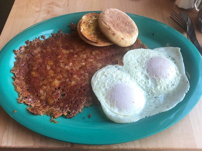 Two perfectly cooked sunny-side-up eggs alongside a crispy hash brown patty—proof that simplicity, when executed flawlessly, creates the most satisfying breakfast symphony. 