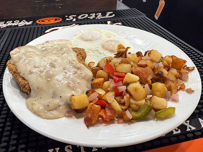 Country-fried steak smothered in peppery gravy alongside crispy home fries and eggs – breakfast architecture that would make Frank Lloyd Wright weep with joy.