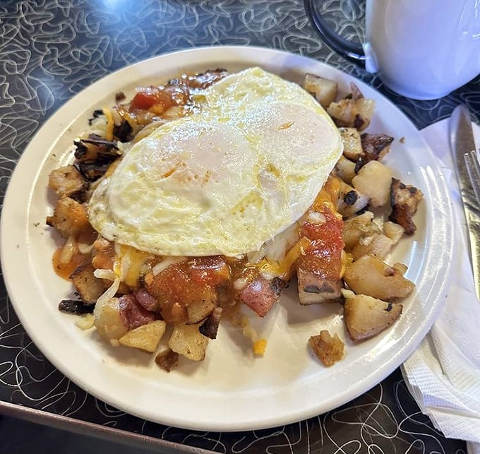 Sunny-side perfection crowns a mountain of seasoned potatoes—proof that sometimes the simplest breakfasts create the most profound happiness.