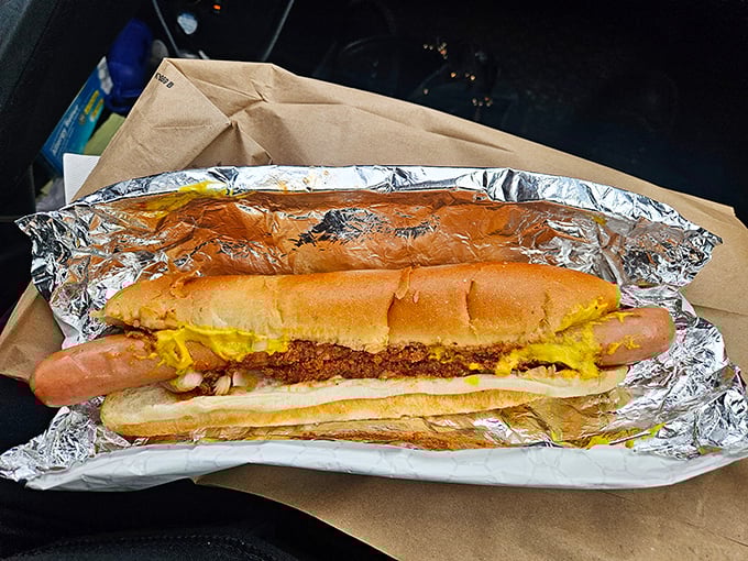 This isn't just a hot dog—it's a masterpiece of mustard, chili, and cheese that requires both hands, several napkins, and absolutely zero regrets.