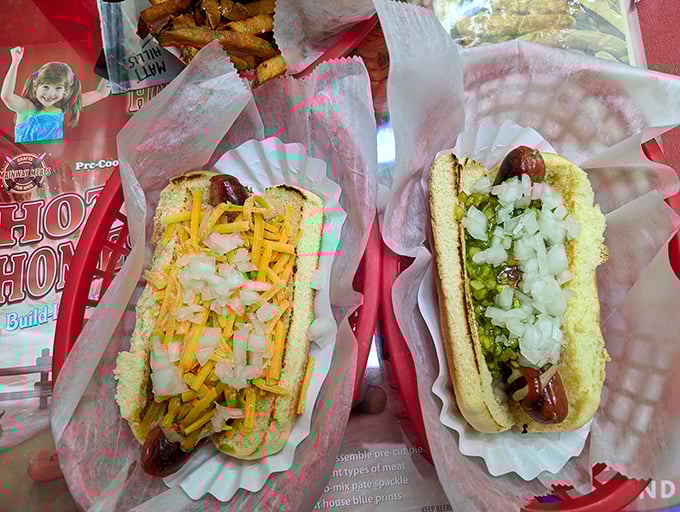 Two dogs living their best lives – one crowned with melted cheddar and onions, the other dressed for success with relish and fresh toppings.