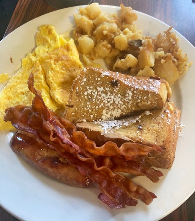 Breakfast perfection doesn't need fancy plating – golden French toast, crispy bacon, fluffy eggs, and home fries that could make a potato proud.