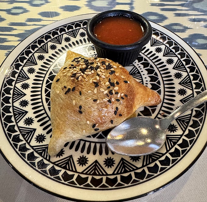 The legendary lamb somsa in all its golden glory. This isn't just pastry—it's architecture, poetry, and comfort food rolled into one flaky triangle of joy.
