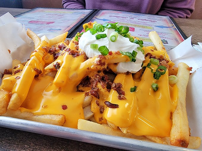 Behold the legendary "Whatever Fries" in all their glory – a golden mountain of potatoes smothered in cheese, bacon bits, and topped with sour cream.