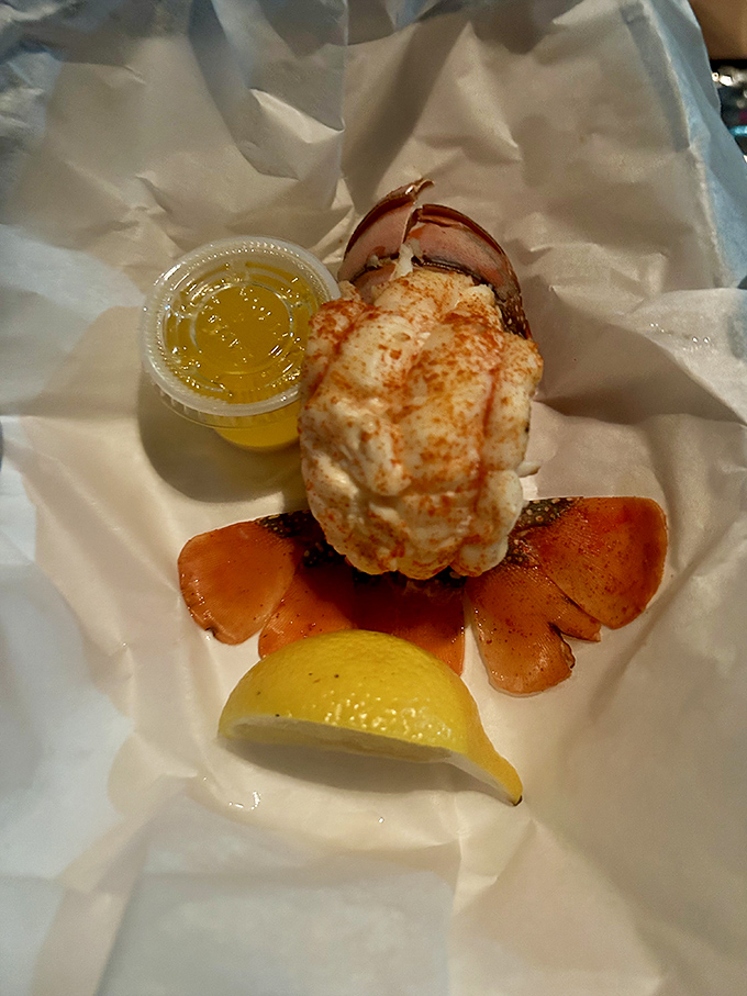 This lobster tail isn't just food—it's a crustacean celebration on parchment paper. The drawn butter stands by like liquid gold awaiting its moment.