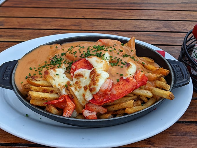 Lobster poutine that makes Canadians jealous—tender chunks of lobster meat lounging atop crispy fries under a blanket of melted cheese and savory sauce.