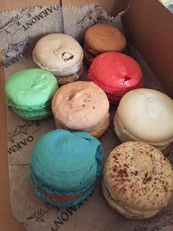 A rainbow of macarons nestled in their box like edible jewels. Each one promises a different journey – from mint green escapades to raspberry revelations.