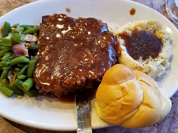 Behold the star attraction: homemade meatloaf swimming in savory gravy alongside green beans and mashed potatoes. Grandma would approve!
