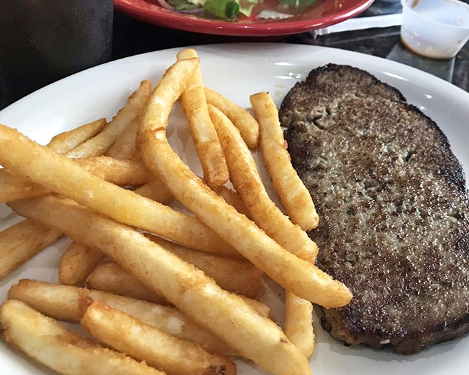 A perfectly seared burger patty with golden fries—the kind of plate that makes you forget about fancy food trends in an instant.