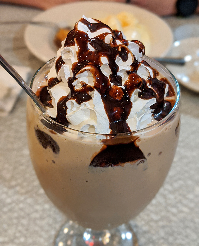 This isn't just a milkshake—it's a chocolate masterpiece topped with real whipped cream and hot fudge that would make Willy Wonka himself weep with joy.