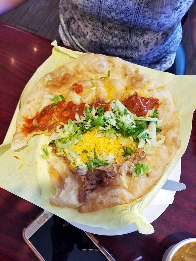 Behold the Navajo taco in all its glory—a perfect storm of crispy-yet-soft fry bread, savory beef, and fresh toppings.