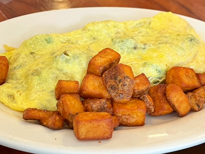 A perfect omelet shouldn't be complicated—just fluffy eggs embracing their fillings alongside home fries that strike the ideal balance between crispy exterior and tender interior.
