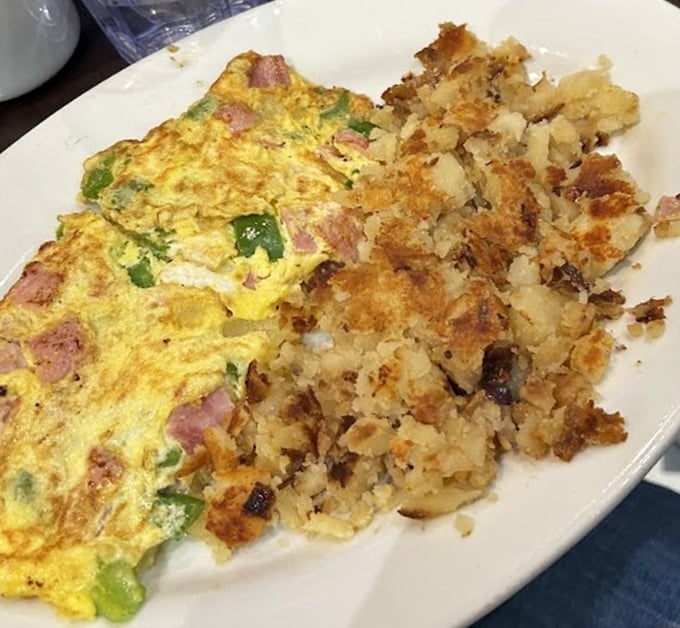 This Western omelet and home fries combo isn't just breakfast—it's a masterclass in diner perfection. The crispy-edged potatoes deserve their own fan club.