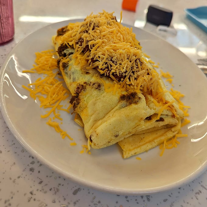 This isn't just an omelet—it's an architectural achievement. Fluffy egg perfection blanketed with a snowfall of cheese that would make any cardiologist nervously clear their throat.