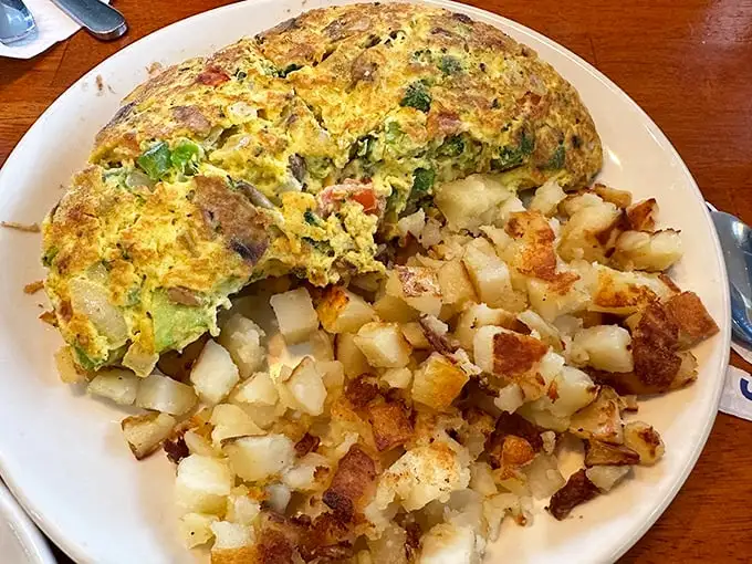 This isn't just an omelet—it's a golden-hued masterpiece with vegetables distributed with the precision of a Renaissance painting. Michelangelo would approve.