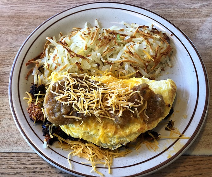 This isn't just an omelet – it's a masterpiece of morning engineering with perfectly melted cheese and crispy hash browns standing guard.