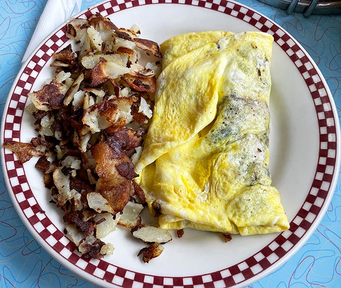This omelet doesn't just whisper "good morning"—it belts it out like Aretha Franklin. Those hash browns deserve their own fan club.