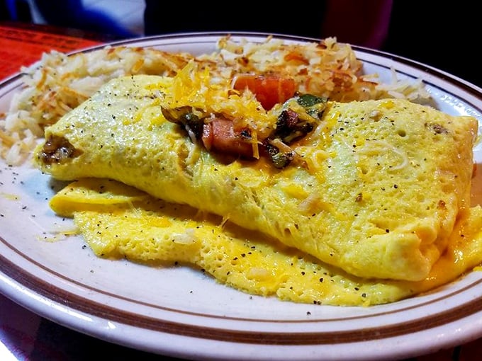 Behold the omelet in its natural habitat—perfectly folded, generously stuffed, and flanked by a golden mountain of hash browns. Breakfast nirvana achieved.