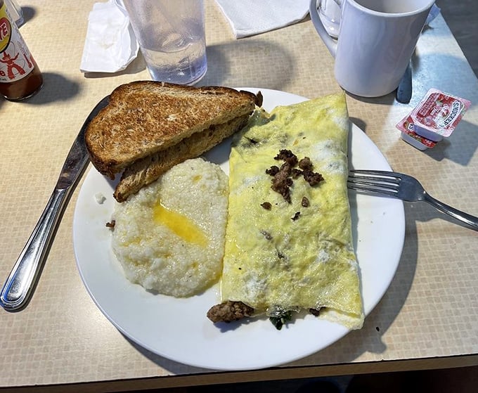 This isn't just an omelet—it's a morning masterpiece with perfectly melted cheese, accompanied by grits that would make any Southerner proud. 