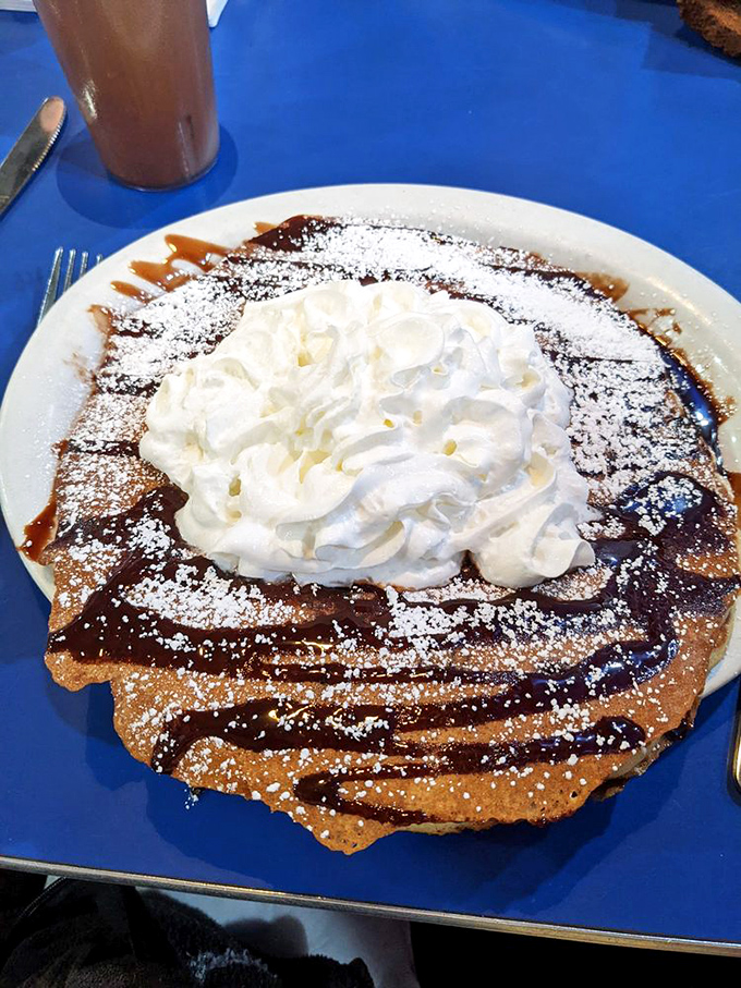 This chocolate-drizzled pancake with whipped cream mountain isn't breakfast – it's dessert masquerading as a morning meal. Resistance is futile.