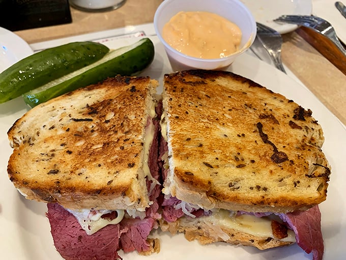 Behold the star attraction: a pastrami sandwich with the perfect meat-to-bread ratio, accompanied by a pickle that means business.