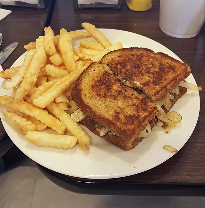 The legendary patty melt in all its glory—perfectly grilled rye bread embracing melted cheese and caramelized onions in a sandwich that deserves its own hall of fame.