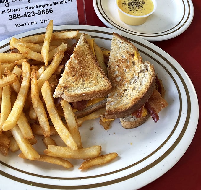 The patty melt—that perfect marriage of beef, cheese, and toasted rye—arrives with fries so golden they deserve their own Florida sunshine tax.