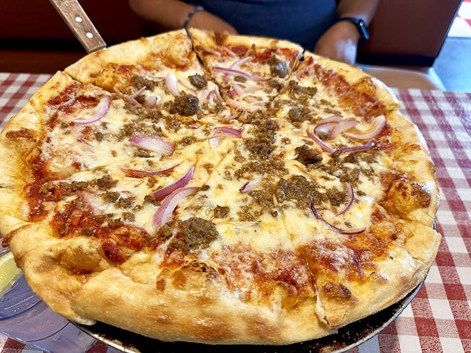This isn't just pizza—it's a perfectly charred canvas where melted cheese, savory meat, and red onions perform a culinary ballet.