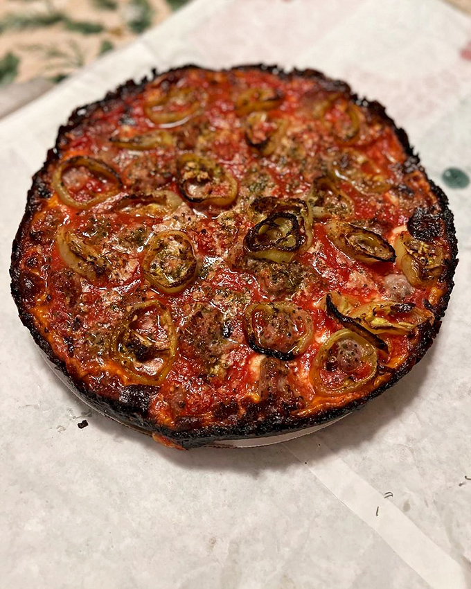 Behold the star attraction: that signature caramelized crust creates a dark amber ring around bubbling cheese and perfectly distributed toppings.