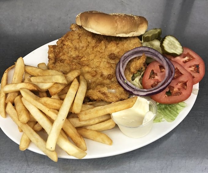 The legendary tenderloin in its natural habitat – a golden-brown disc of perfection that makes the bun look like it's wearing a meat sombrero.